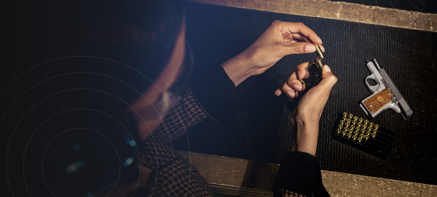 Blurred faded image of a man in shadow pointing a firearm at a range target